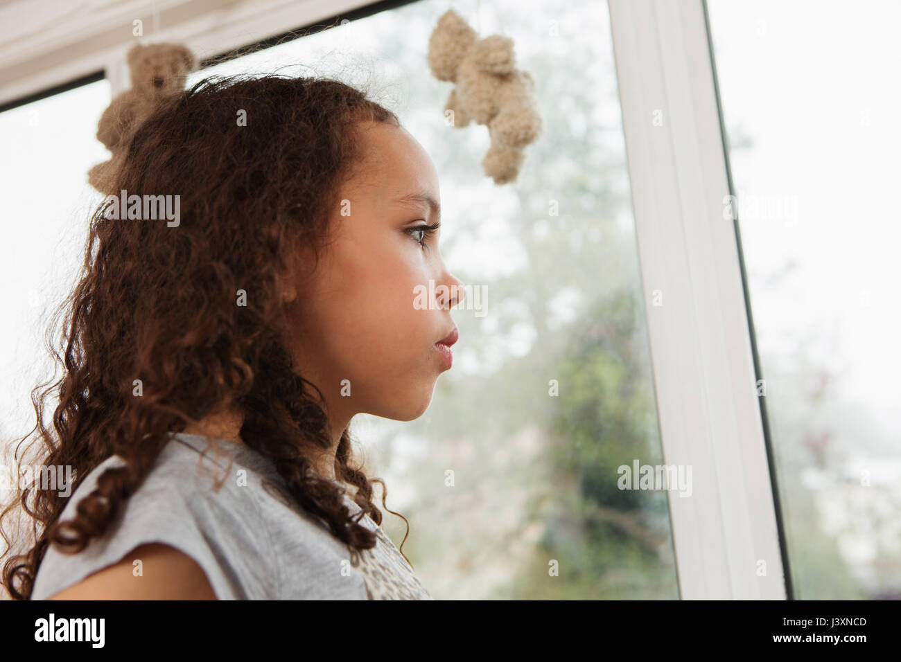 Girl looking out of window Stock Photo - Alamy