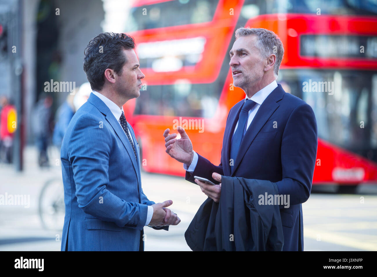 Businessmen in street talking, London, UK Stock Photo - Alamy