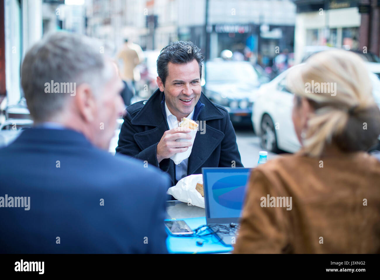 Businesspeople at pavement cafe having working lunch Stock Photo - Alamy