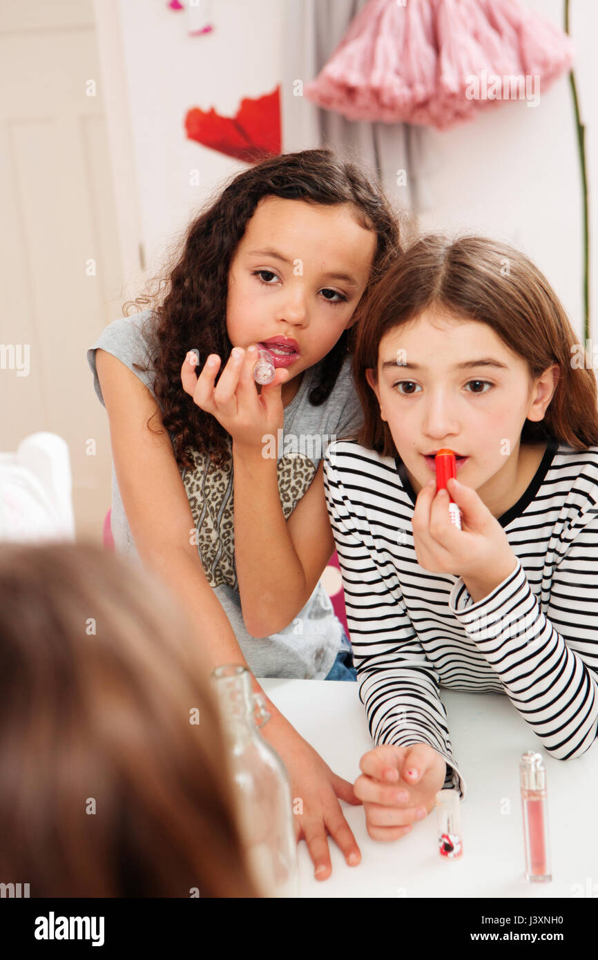 Girls applying makeup in mirror Stock Photo - Alamy
