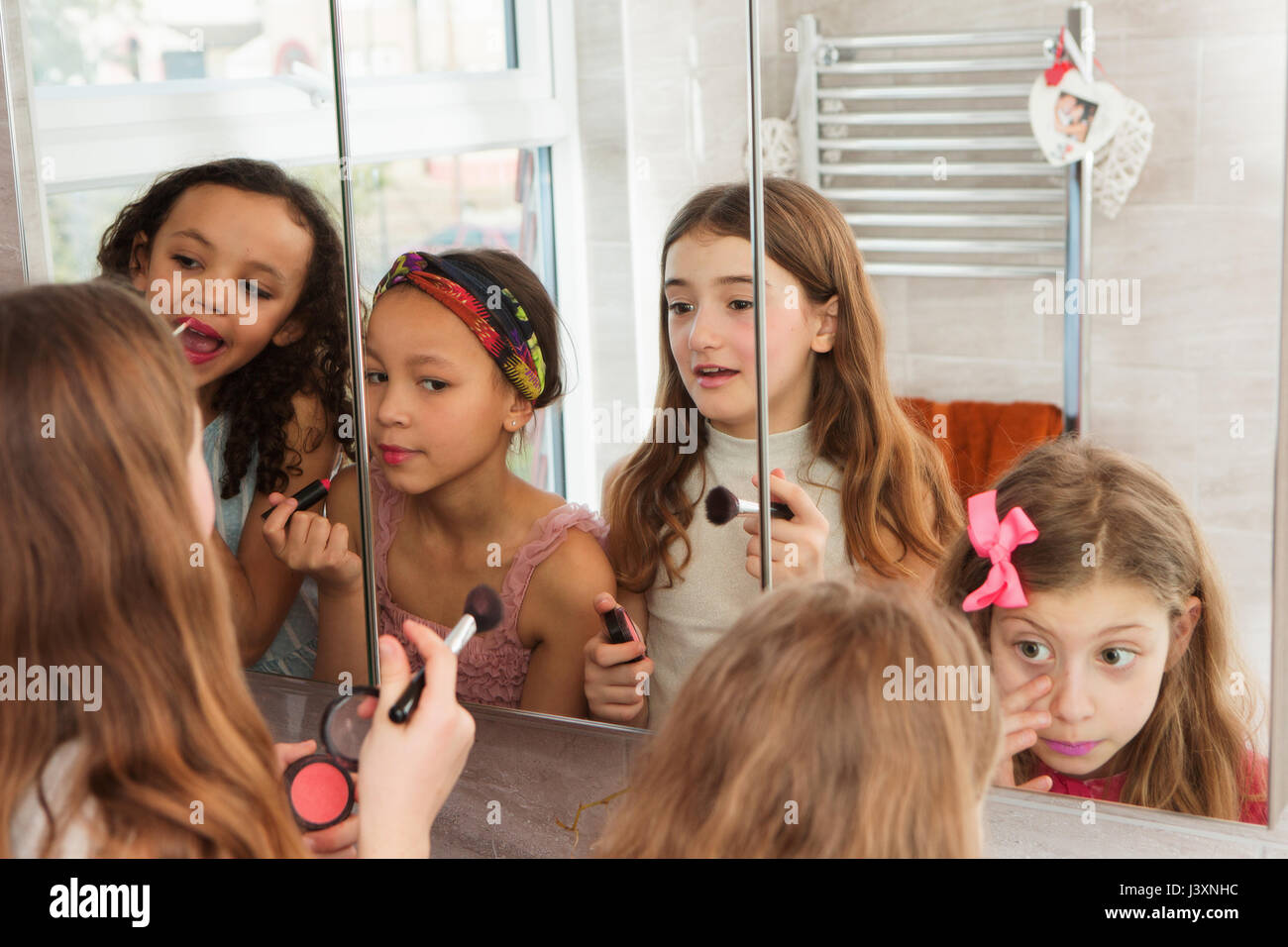 Girls applying makeup in mirror Stock Photo - Alamy