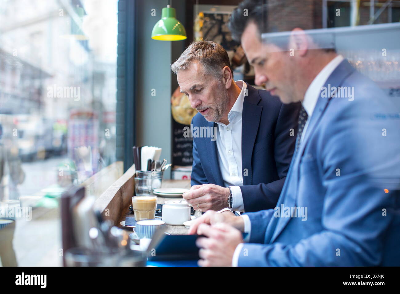 Two businessmen having working lunch in restaurant Stock Photo - Alamy