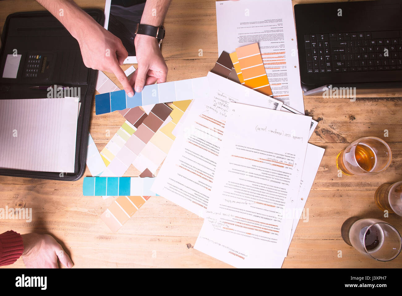 Top view of young designers discussing new project with laptop and ...