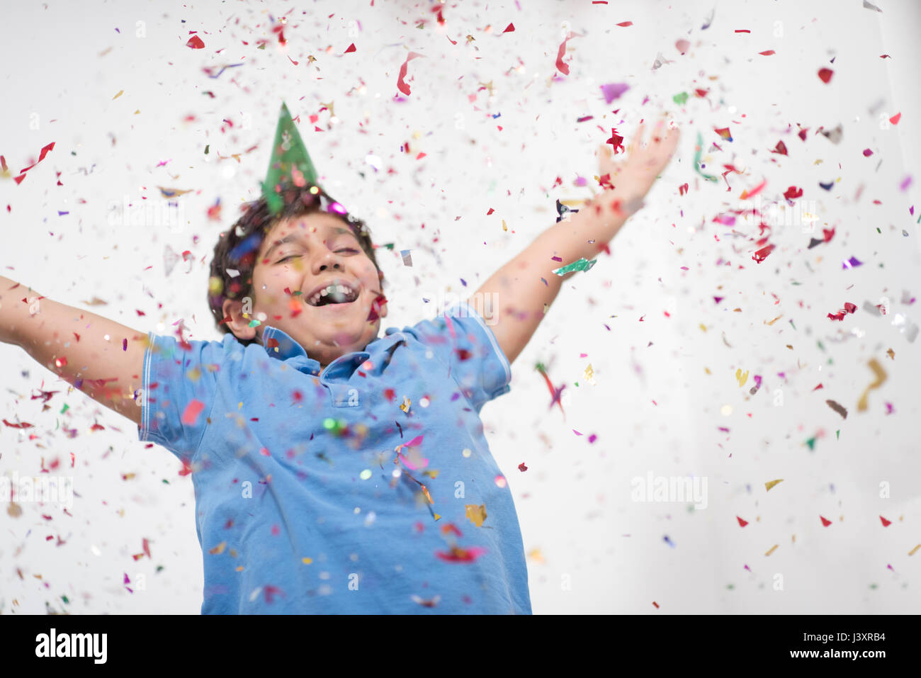 Happy kid celebrating party with blowing confetti Stock Photo - Alamy