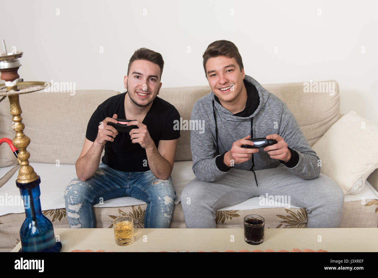 Two Brothers or Friends Playing Video Games Together as They Relax on a ...