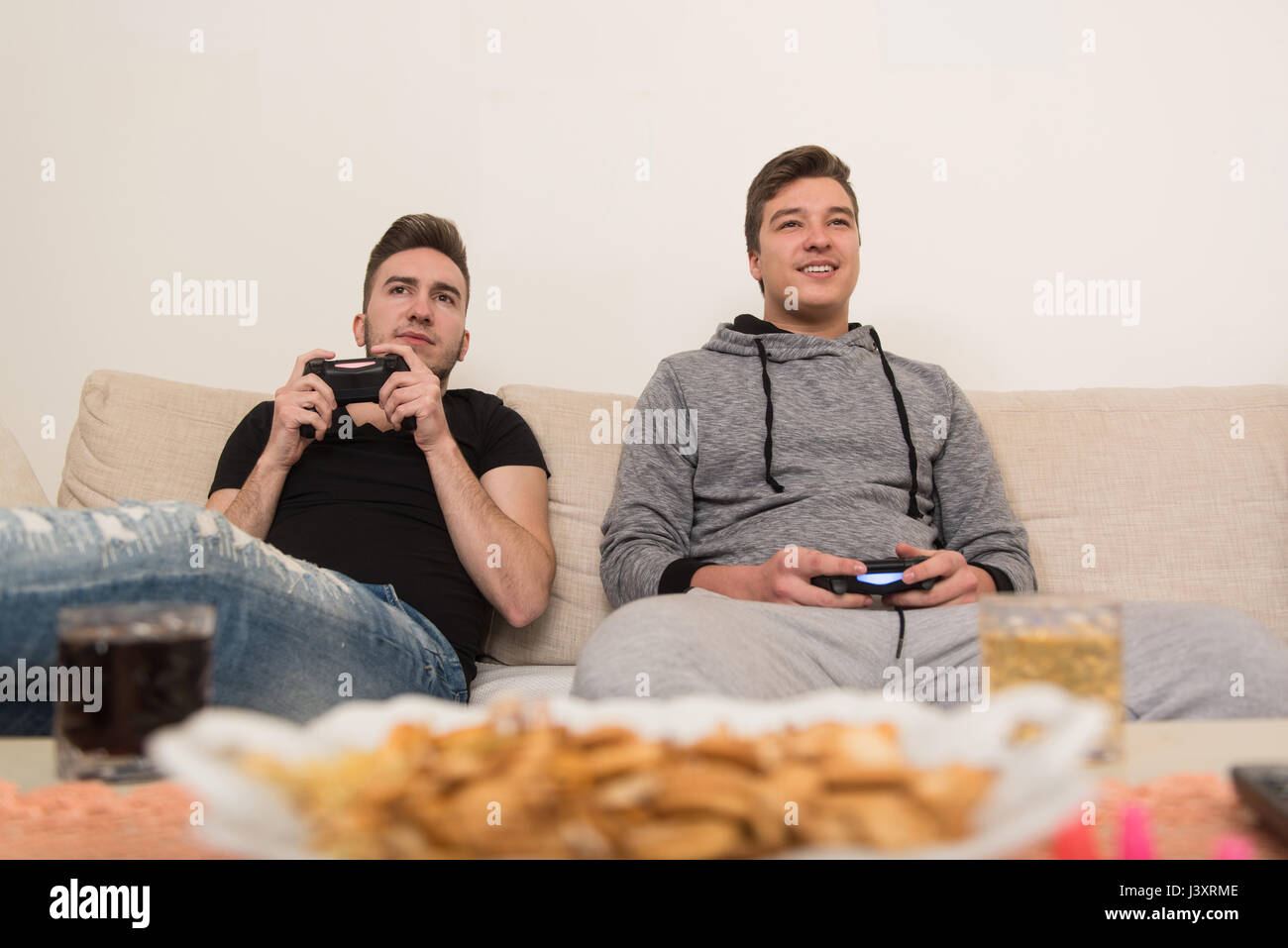 Two Young Brothers Having Happy Time Together Playing Video Games At ...