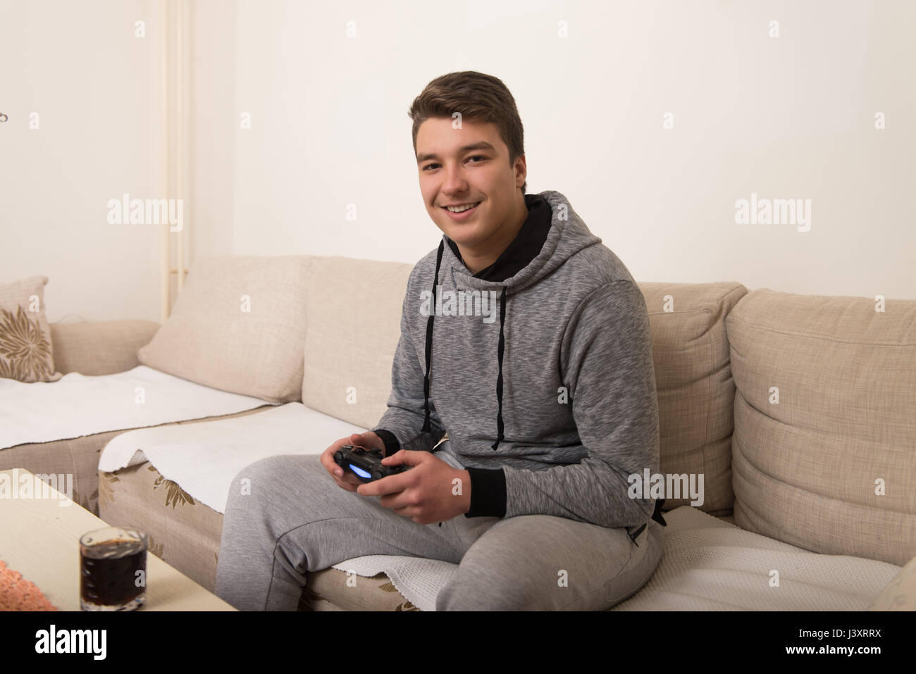 Young Gamer Sitting On Sofa And Playing Video Games At Home Stock Photo ...