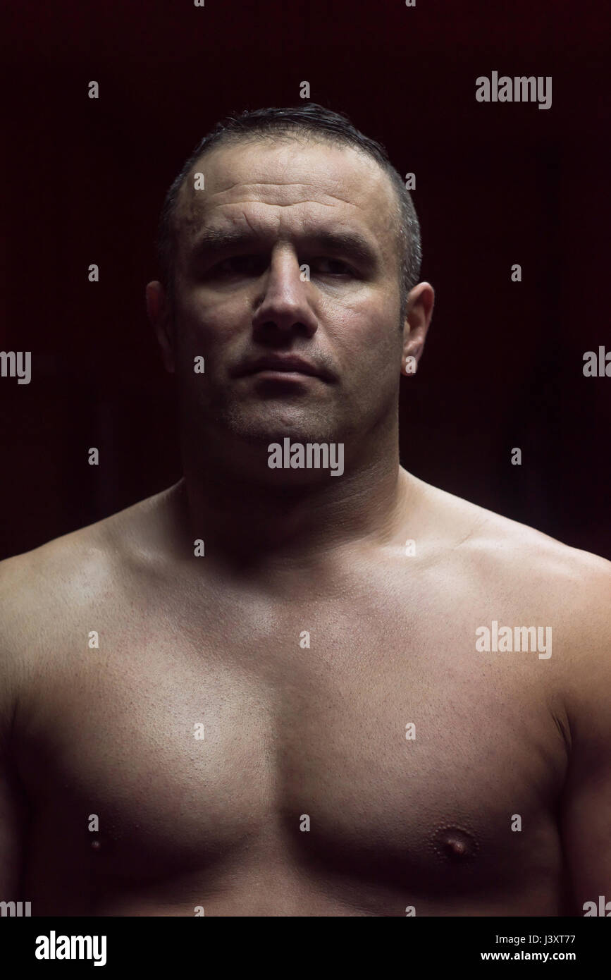 portrait of muscular professional kickboxer who standing in the ring ...