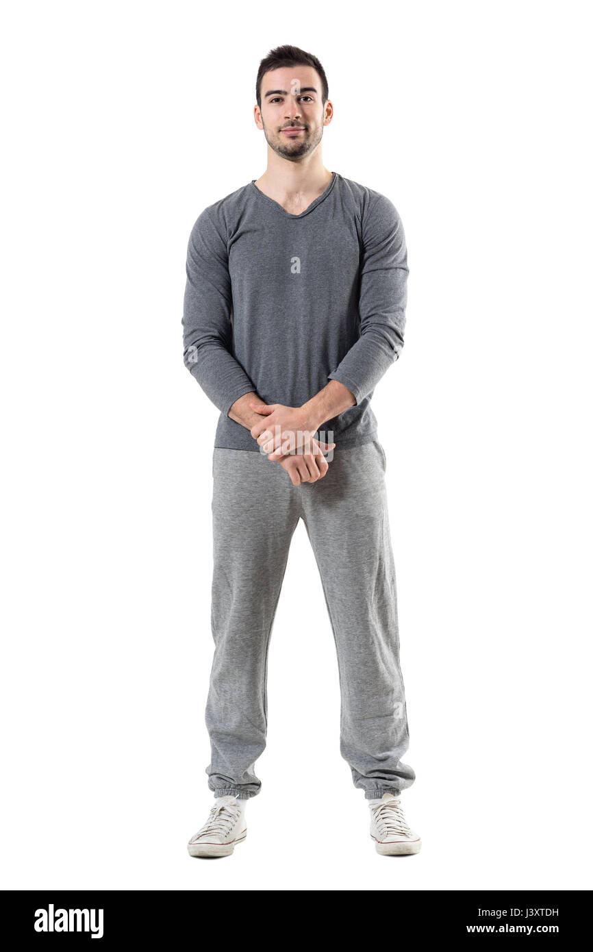 Friendly smiling young sporty fit man with clasped hands looking at ...