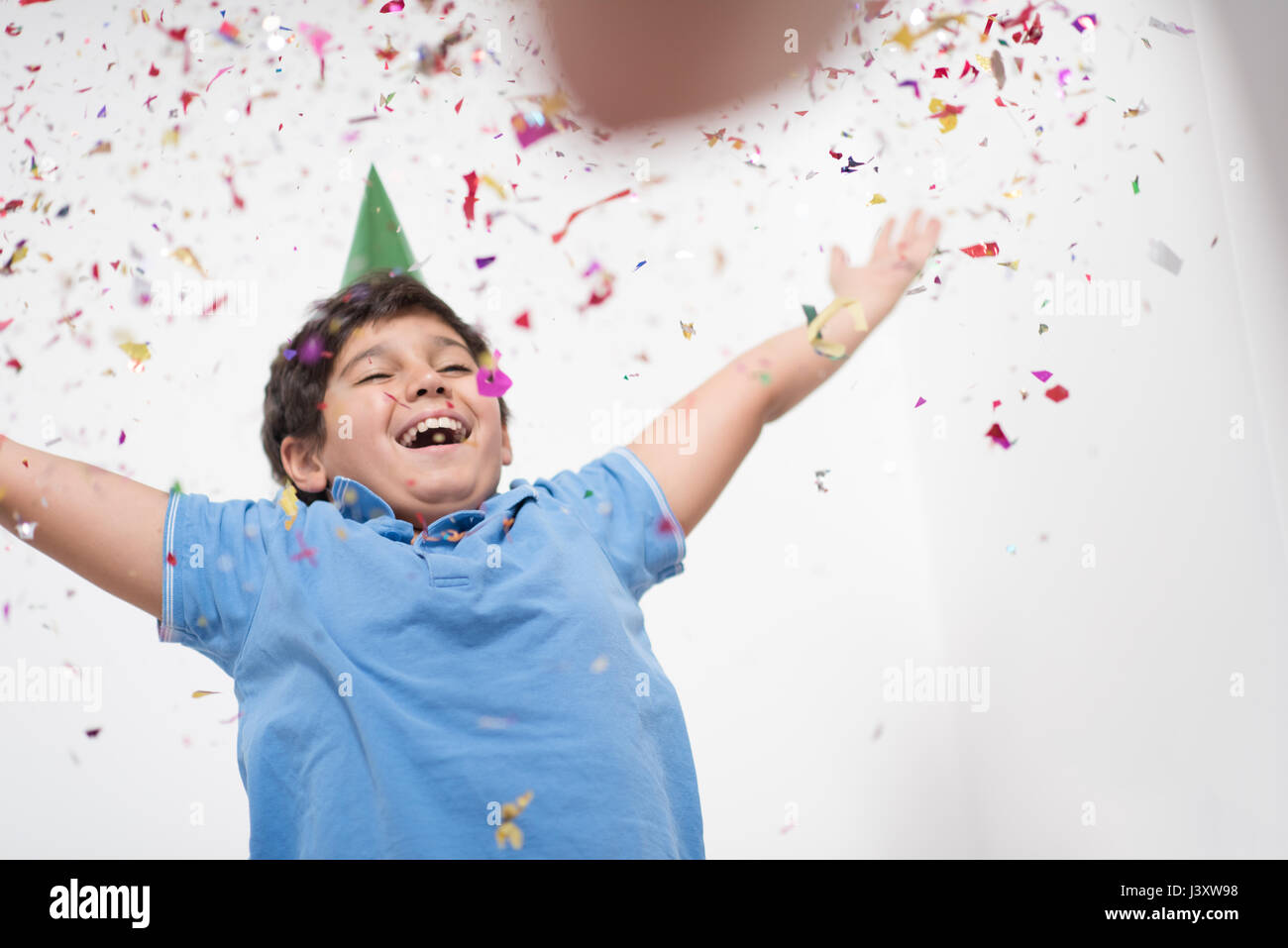 Happy kid celebrating party with blowing confetti Stock Photo - Alamy