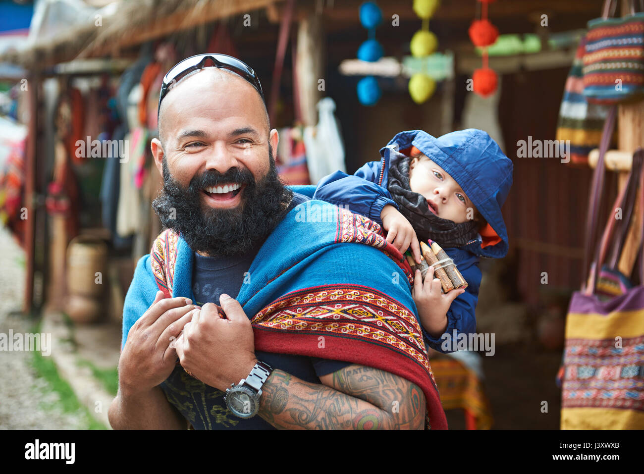 Man with kid in Peru market having fun with alpaca clothes Stock Photo ...