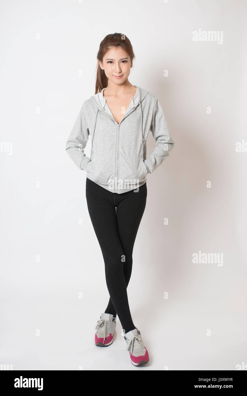 Fit woman athlete in gym clothes posing standing facing the camera ...