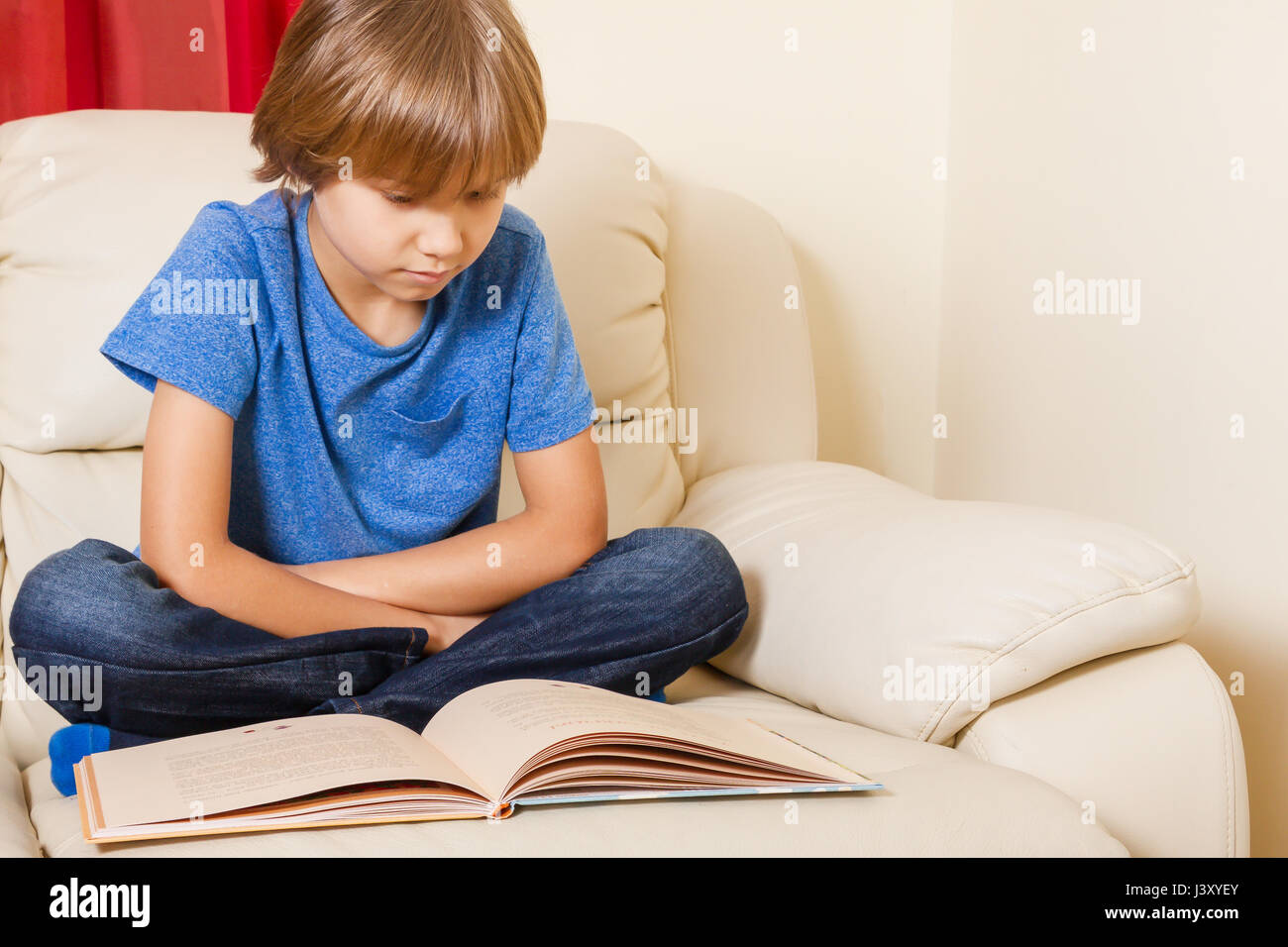 Little kid reading a book at home Stock Photo - Alamy