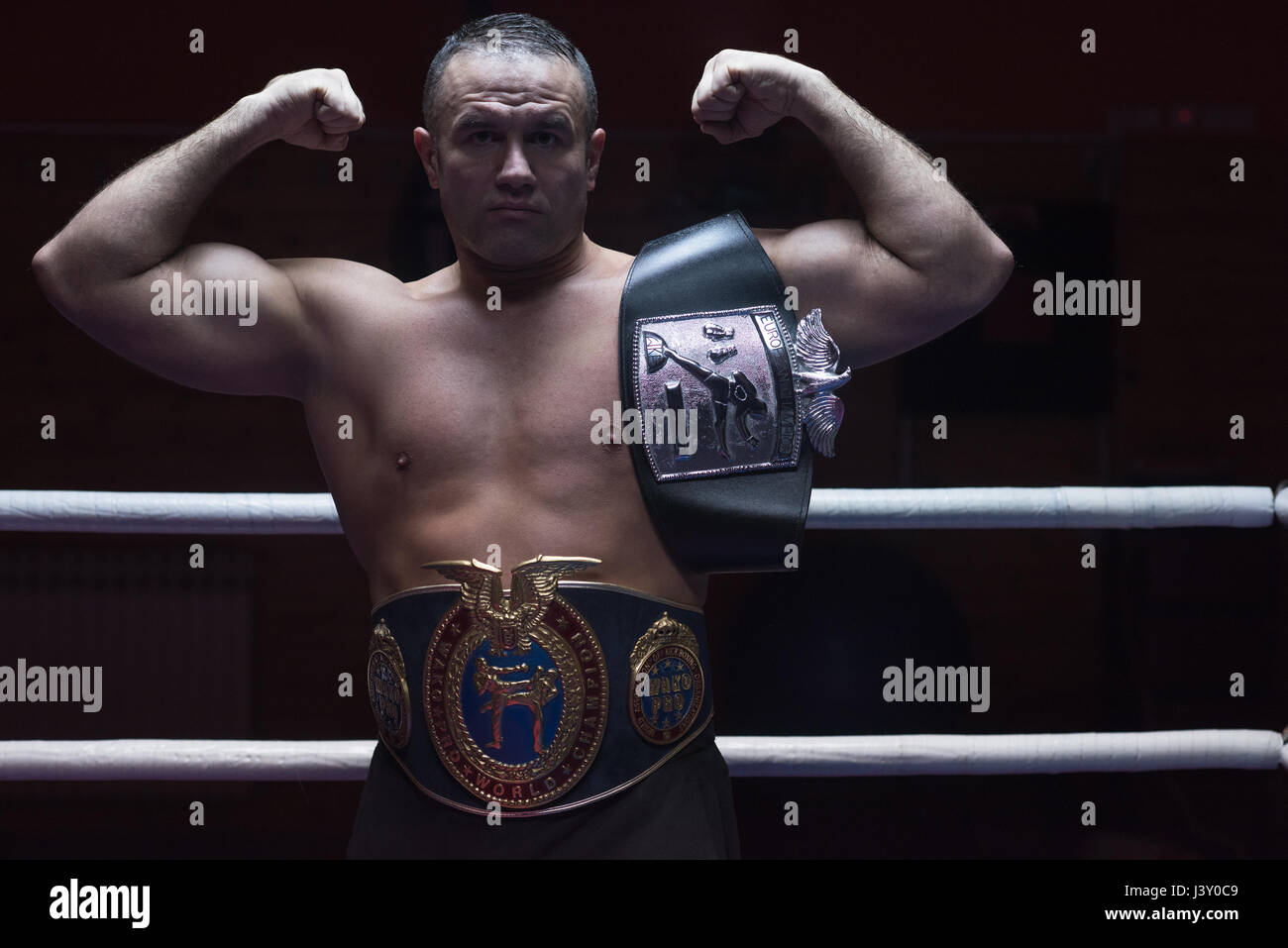 portrait of muscular professional kick boxer with his championship belt ...