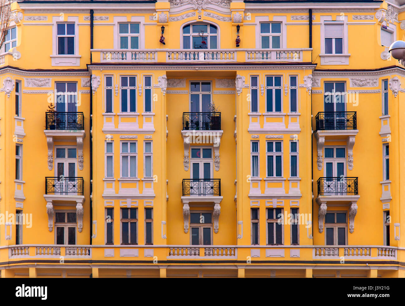 Urban yellow building with blue window Stock Photo - Alamy