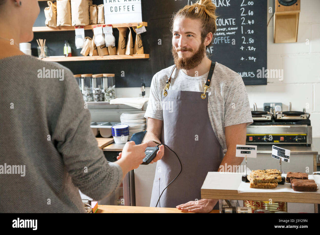 Customer paying contactless in a cafe at the counter Stock Photo - Alamy