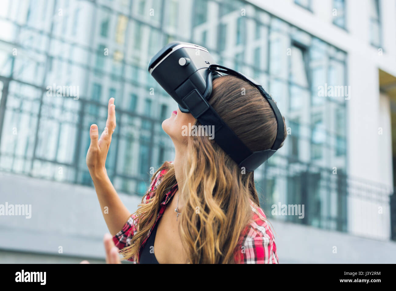 beautiful young girl with virtual reality VR headset on the street ...