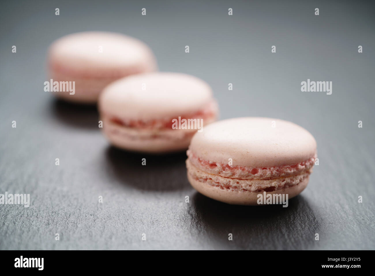 light pink macarons on slate background Stock Photo - Alamy