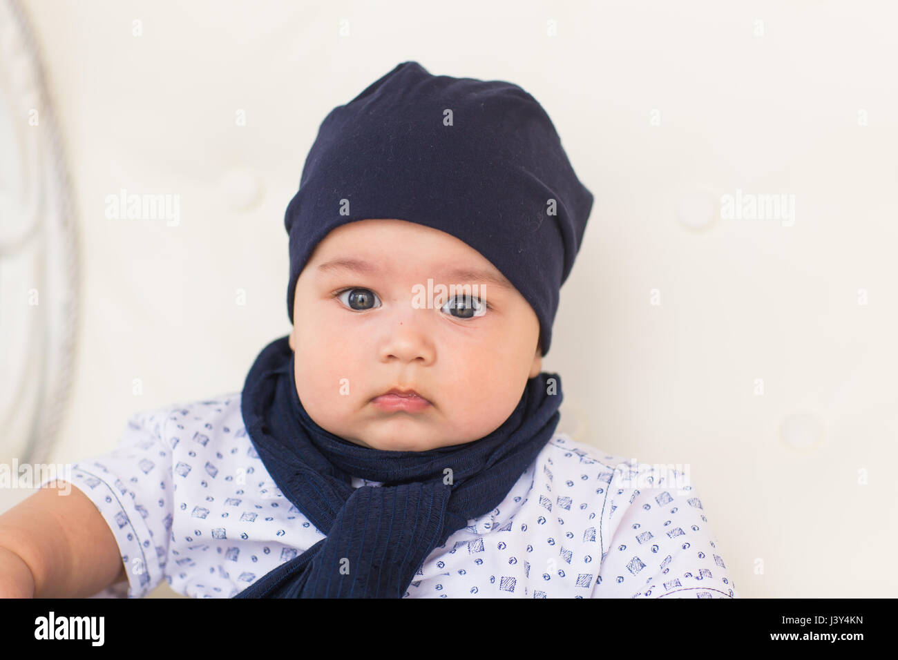 Close up portrait of cute baby boy wearing blue hat Stock Photo - Alamy