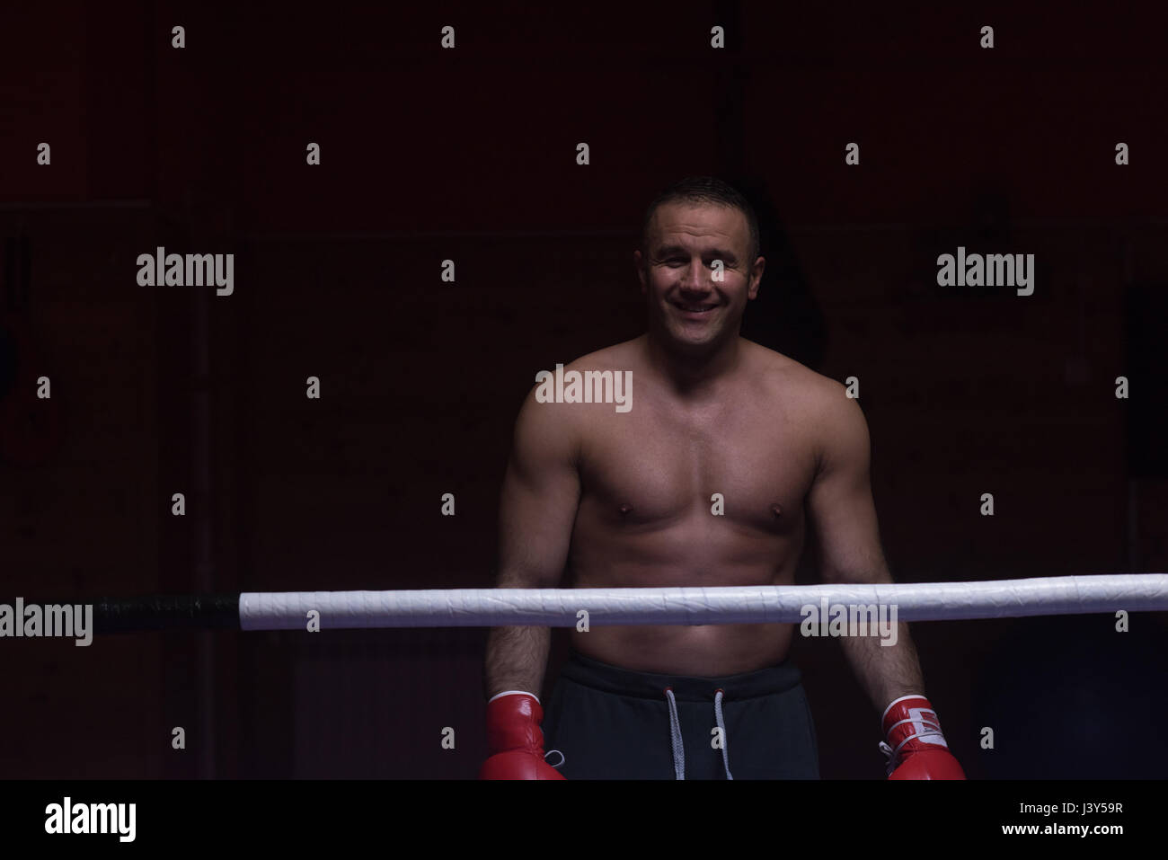 portrait of muscular professional kickboxer who standing in the ring ...
