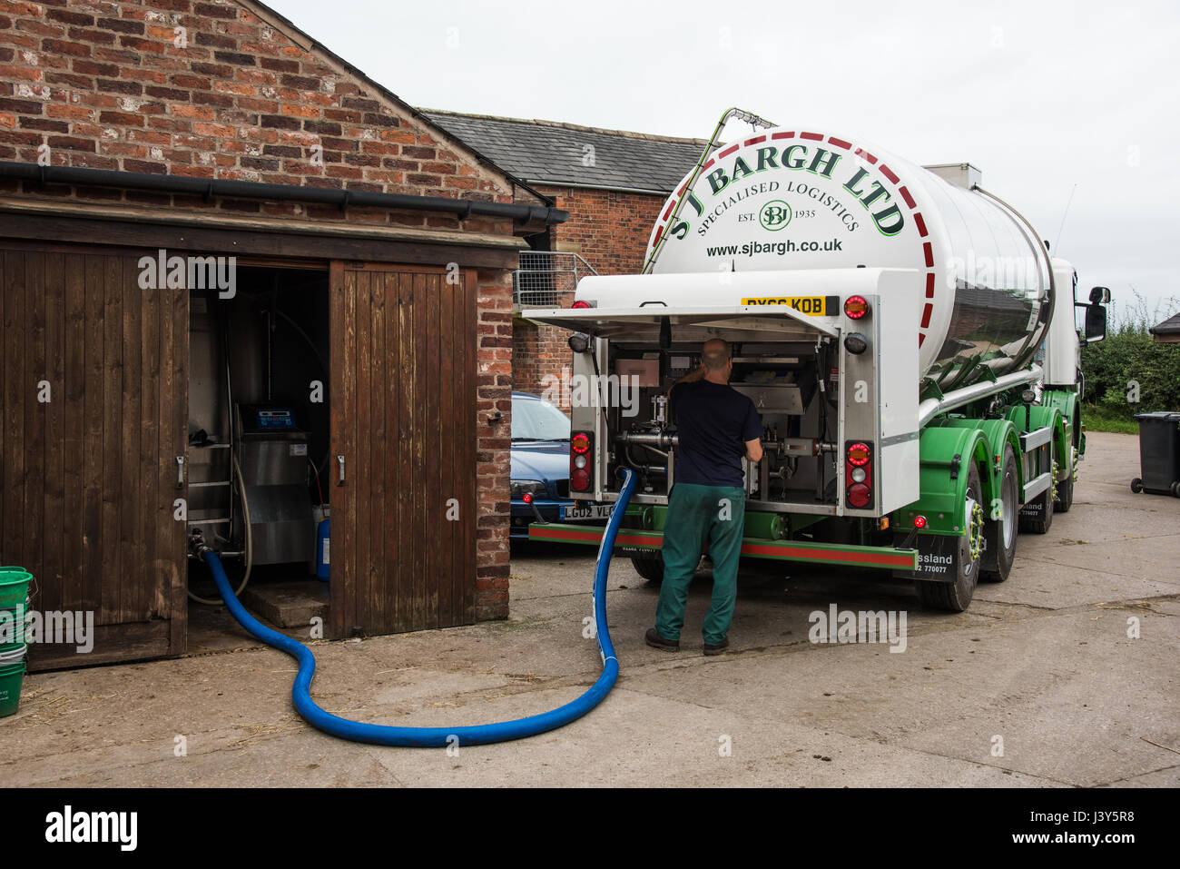 A milk tanker lorry collecting milk from a farm, Preston, Lancashire.UK ...