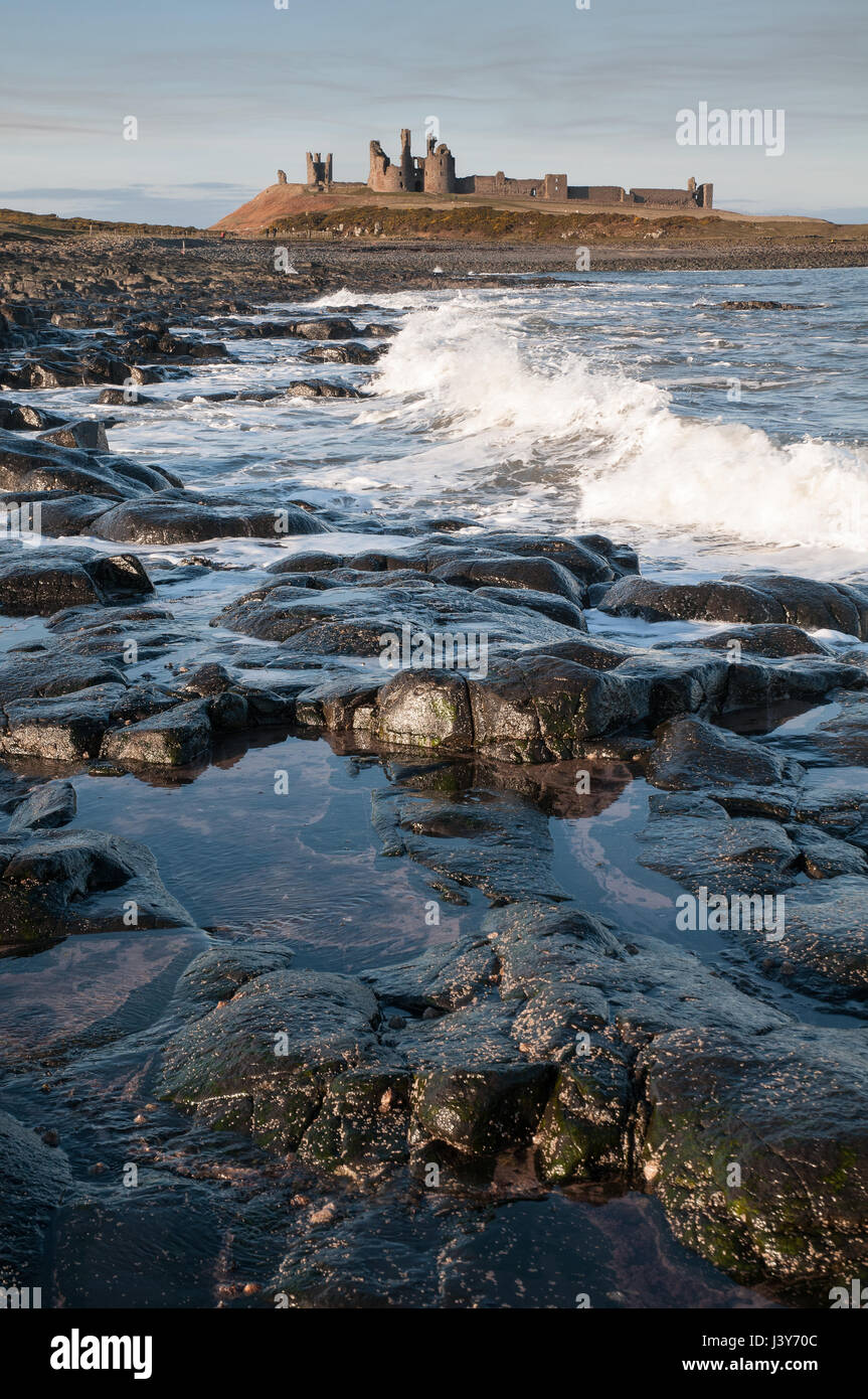 Dunstanburgh Castle on its Whin Sill outcrop, seen from the south. The ...