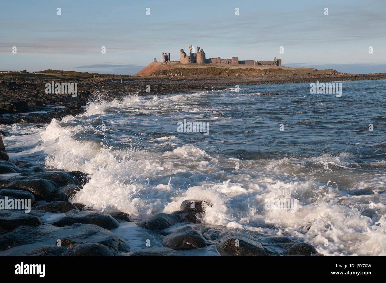 Dunstanburgh Castle on its Whin Sill outcrop, seen from the south. The ...