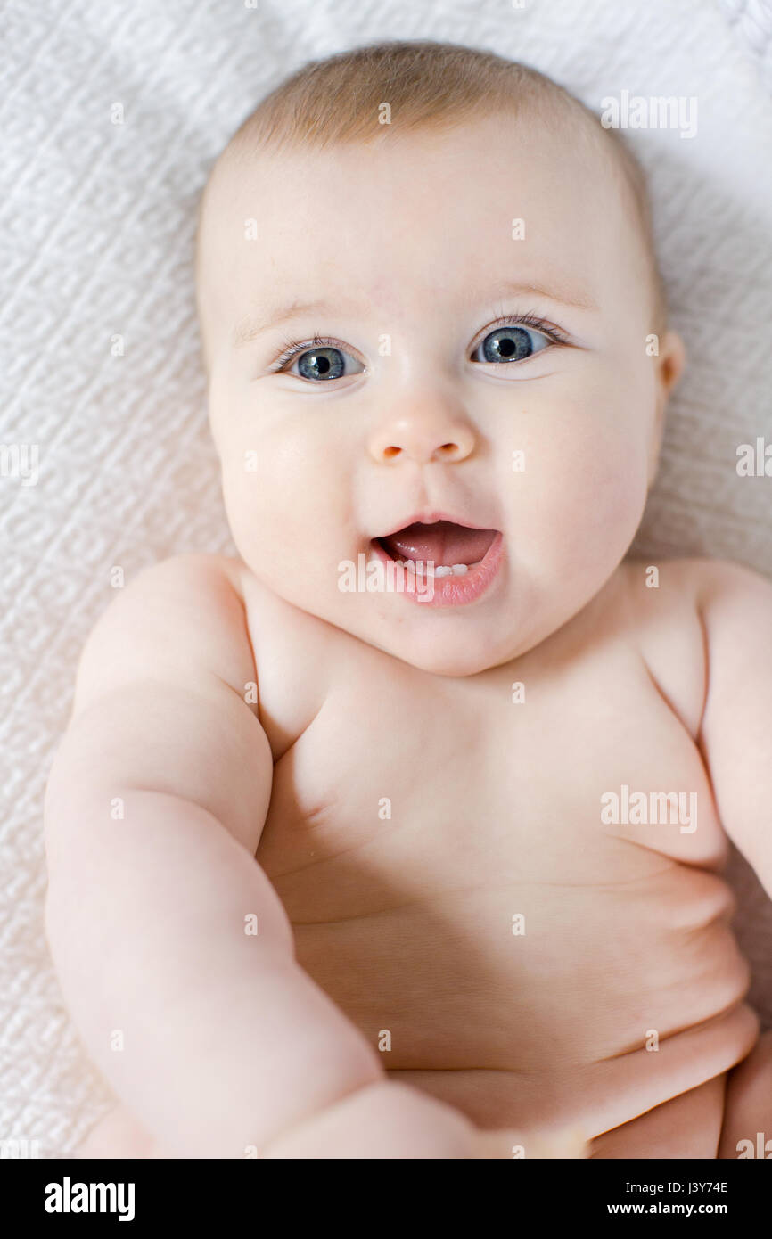 Overhead portrait of blue eyed baby girl on bed Stock Photo - Alamy