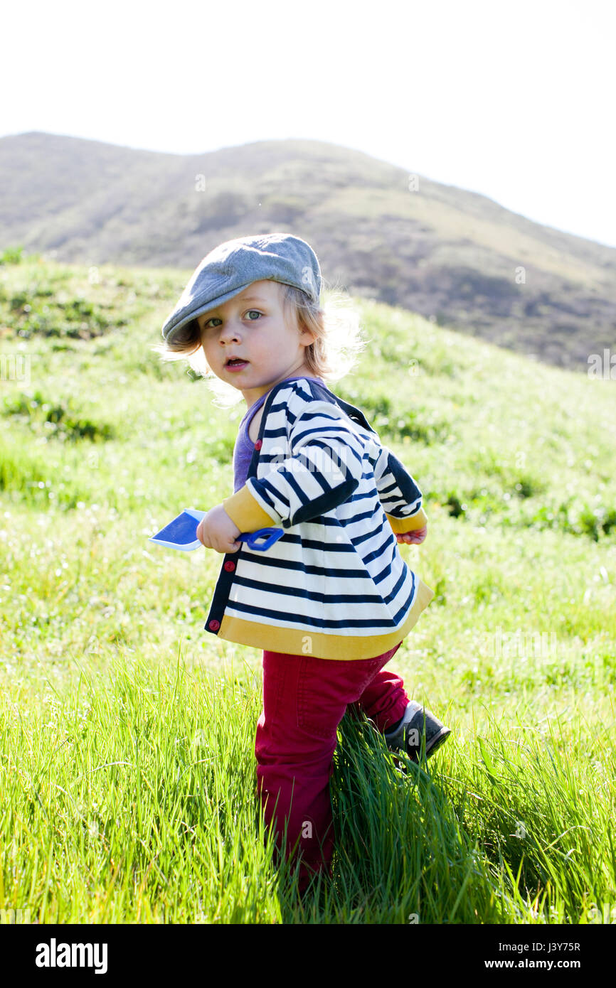 Portrait of male toddler looking back while toddling in grass Stock ...