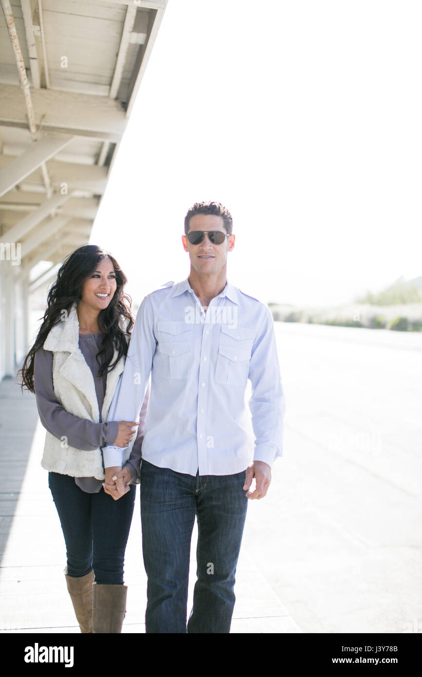 Romantic couple strolling hand in hand by chalets Stock Photo - Alamy