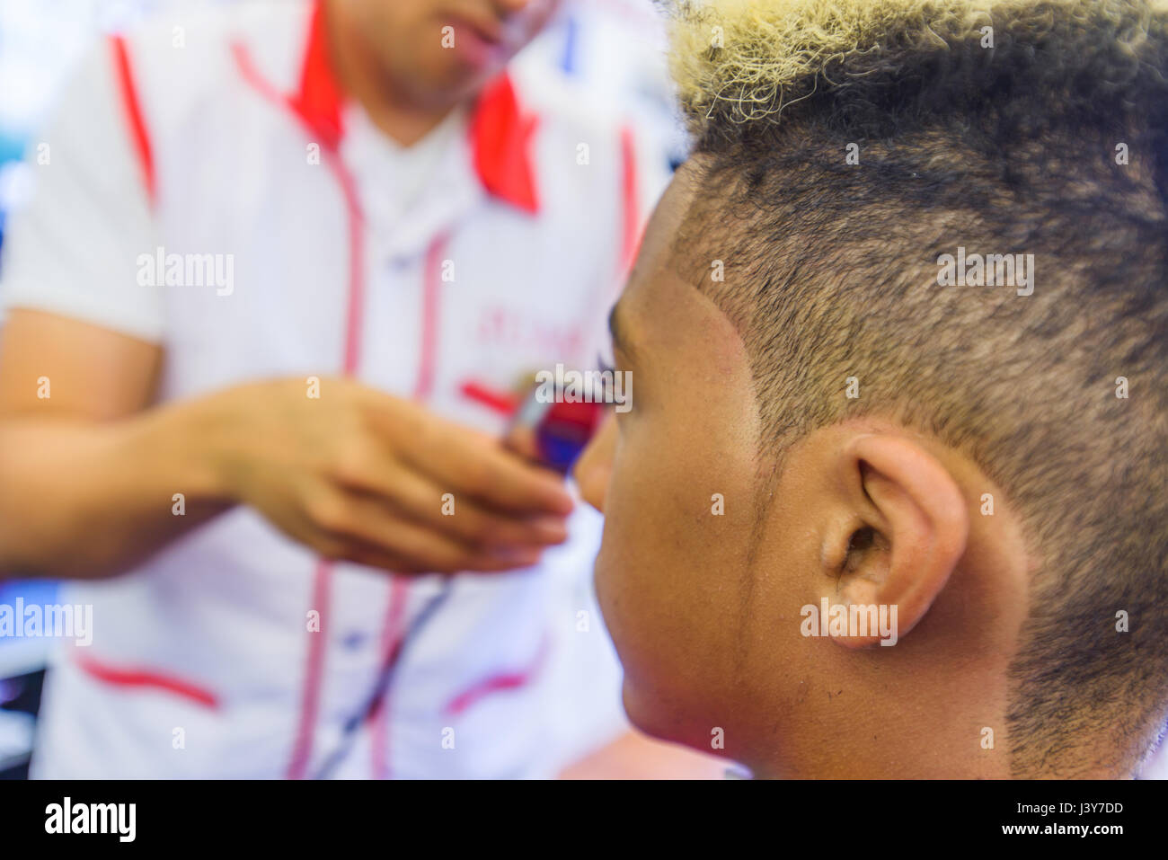 Hairdresser cutting teenage boy's hair in barbershop Stock Photo - Alamy