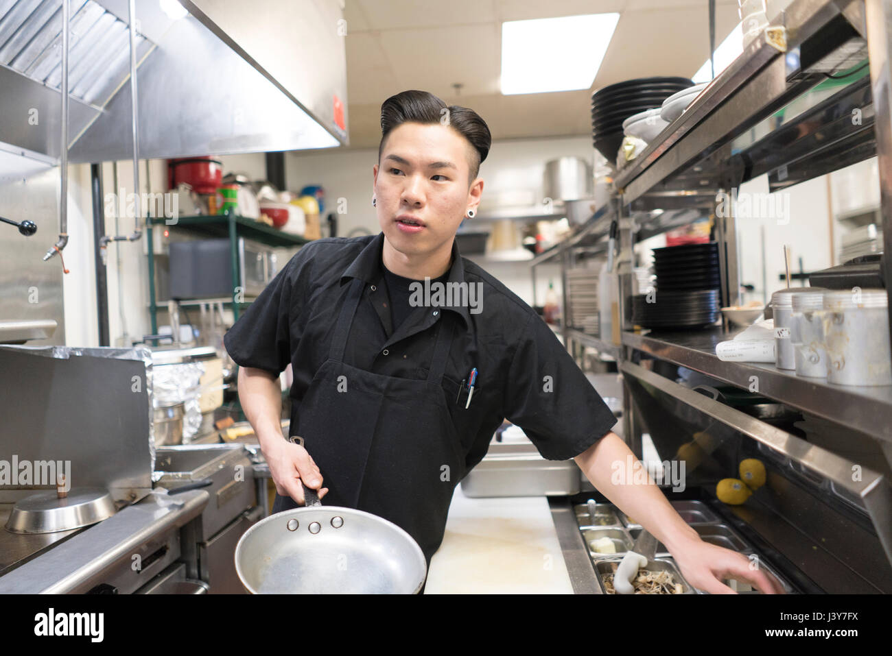 Chef cooking in commercial kitchen Stock Photo - Alamy