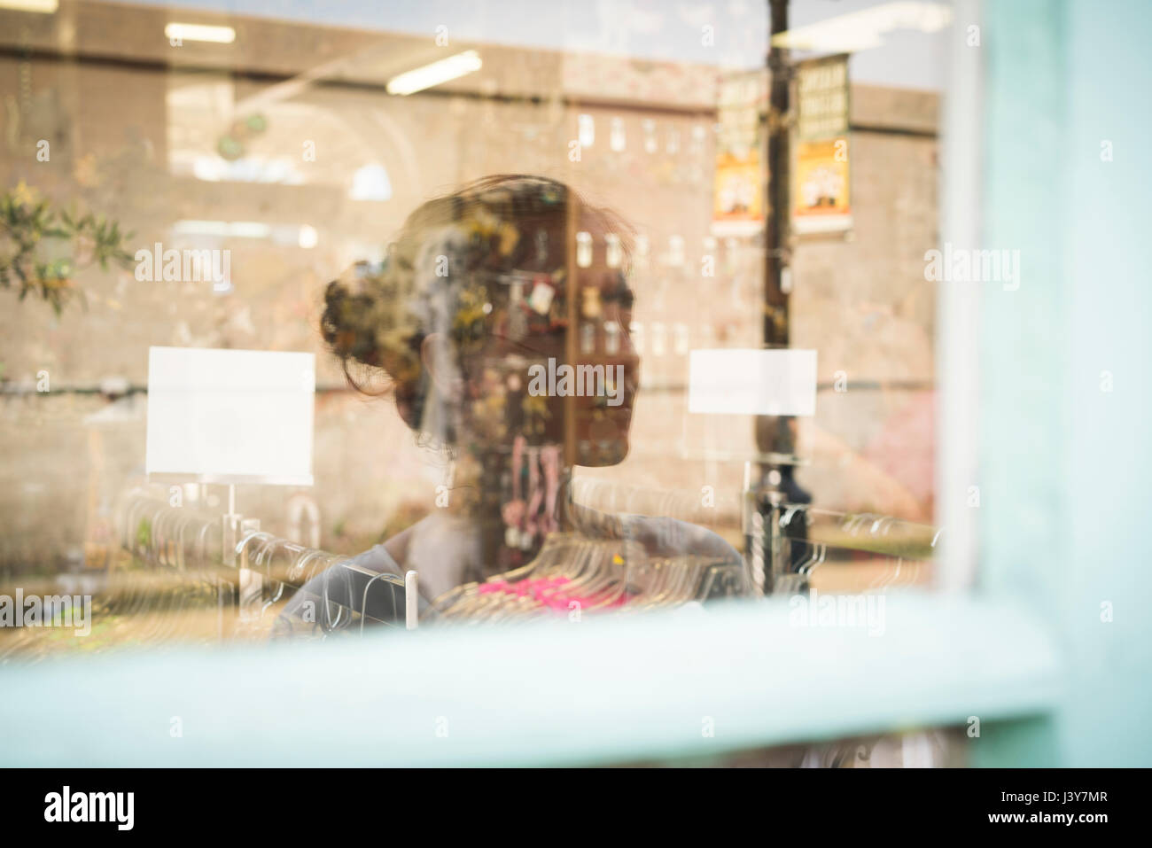 Reflection of woman in shop window Stock Photo - Alamy