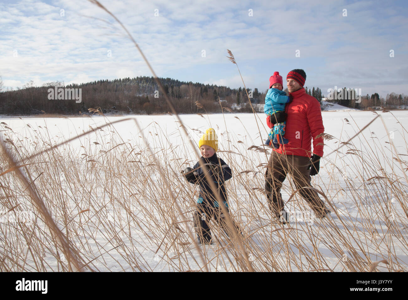 Father walking with two sons in snow covered landscape Stock Photo - Alamy