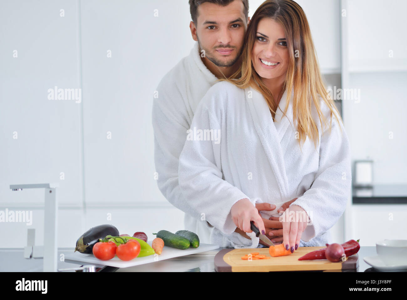 Happy couple cooking breakfast together in the kitchen Stock Photo - Alamy