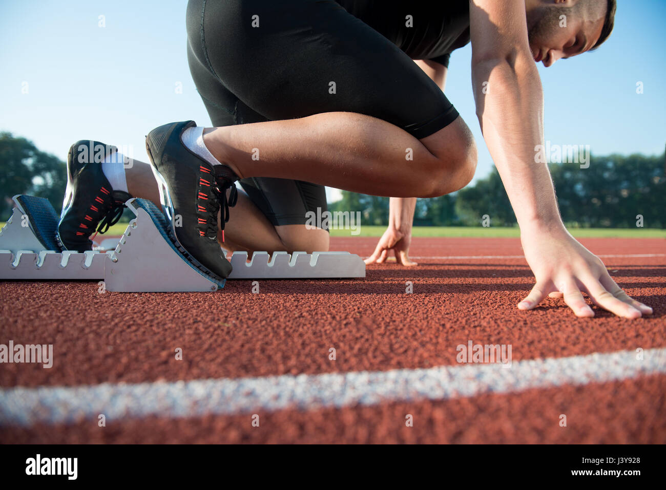 Runners preparing for race at starting blocks Stock Photo - Alamy
