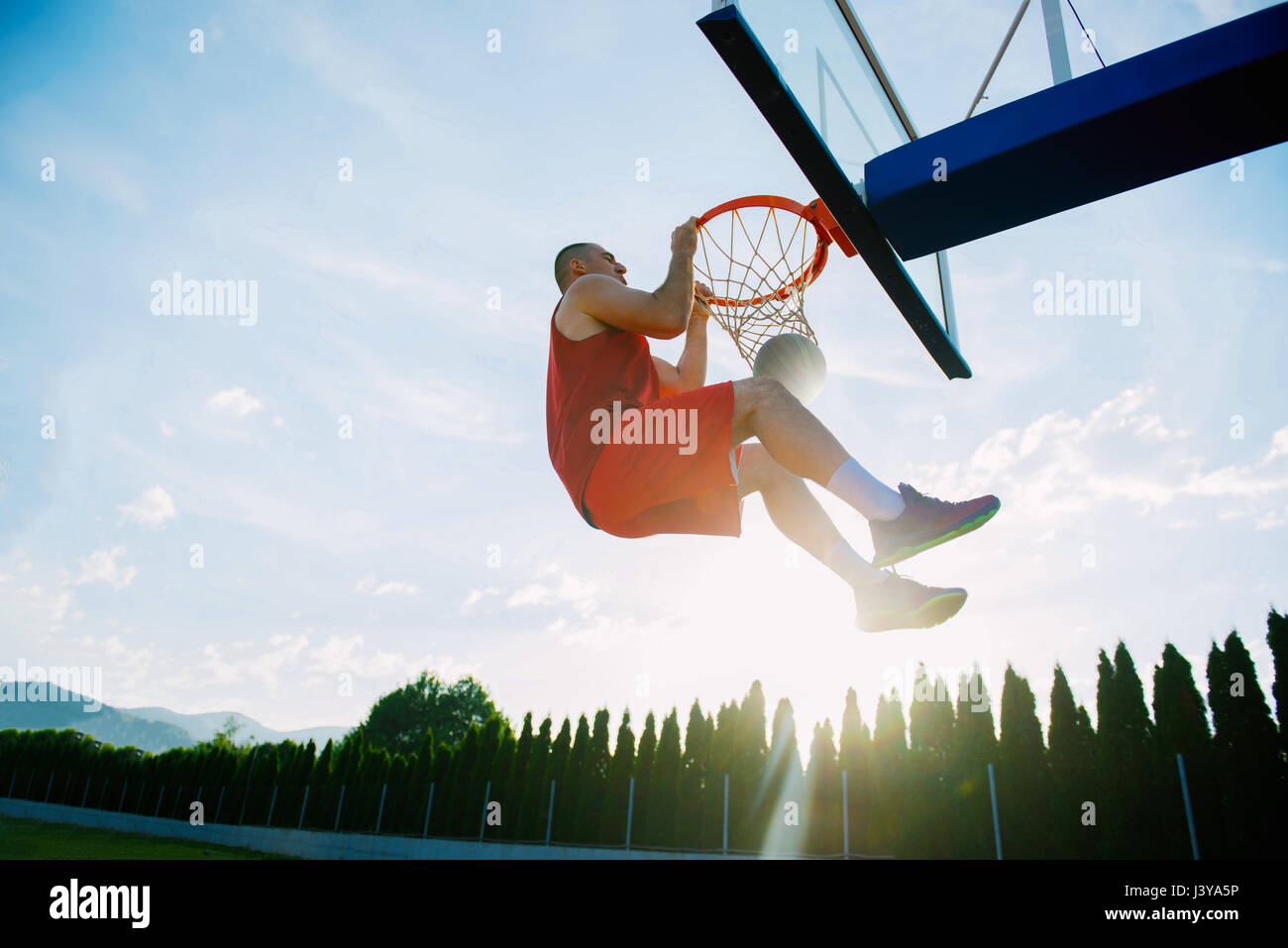 Young man jumping and making a fantastic slam dunk playing stree Stock ...
