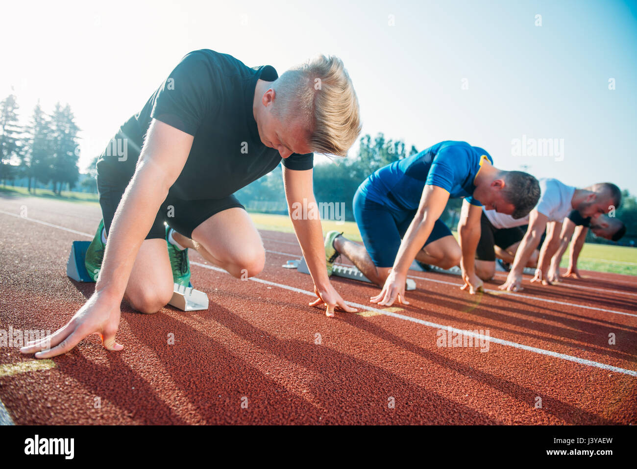 Runners preparing for race at starting blocks Stock Photo - Alamy
