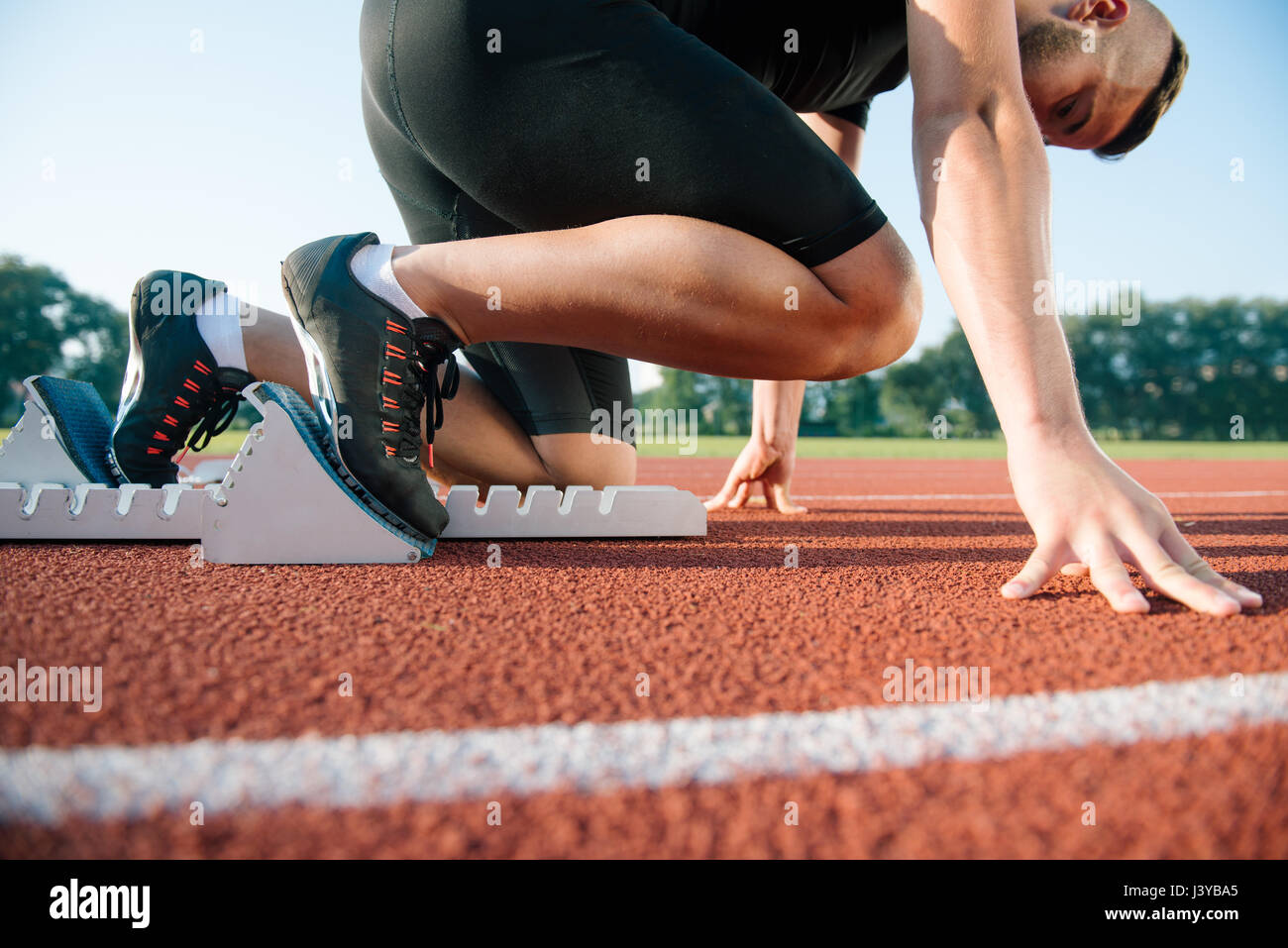 Runners preparing for race at starting blocks Stock Photo - Alamy
