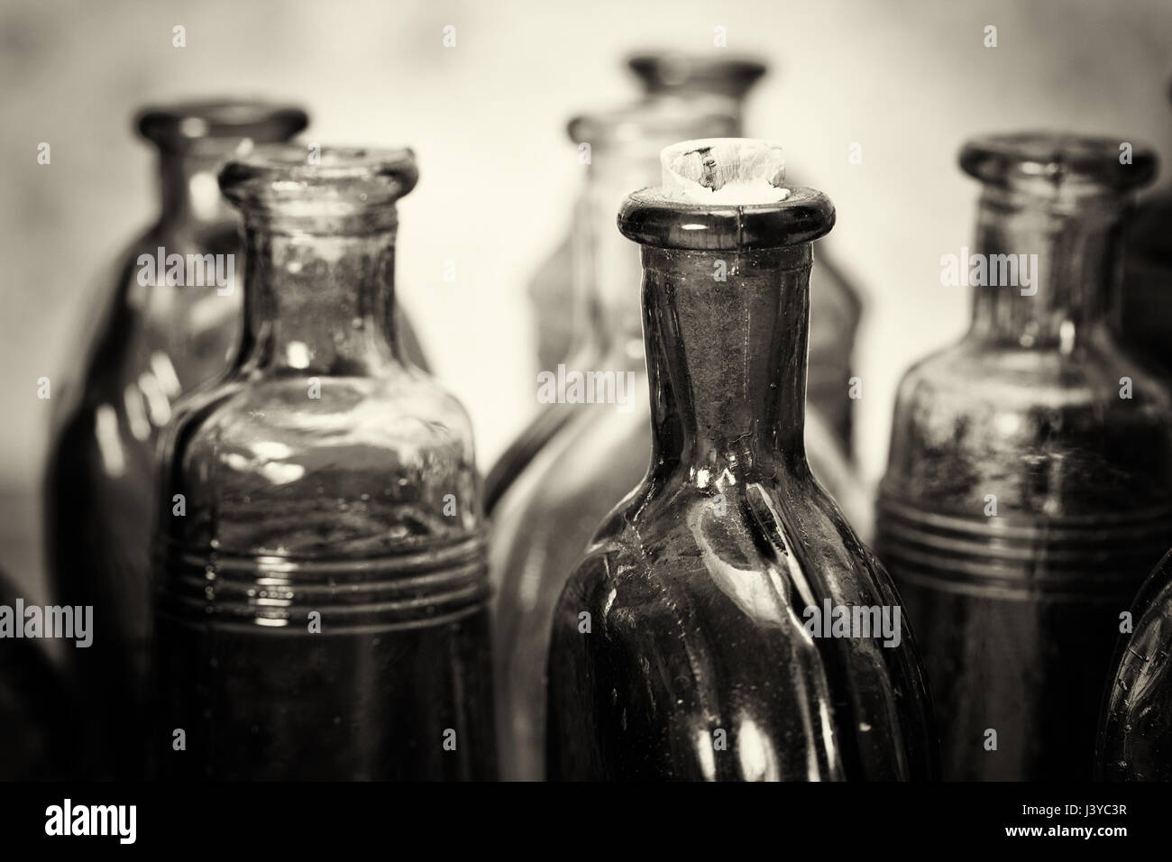 Selection of coloured glass bottles on a rustic background Stock Photo ...