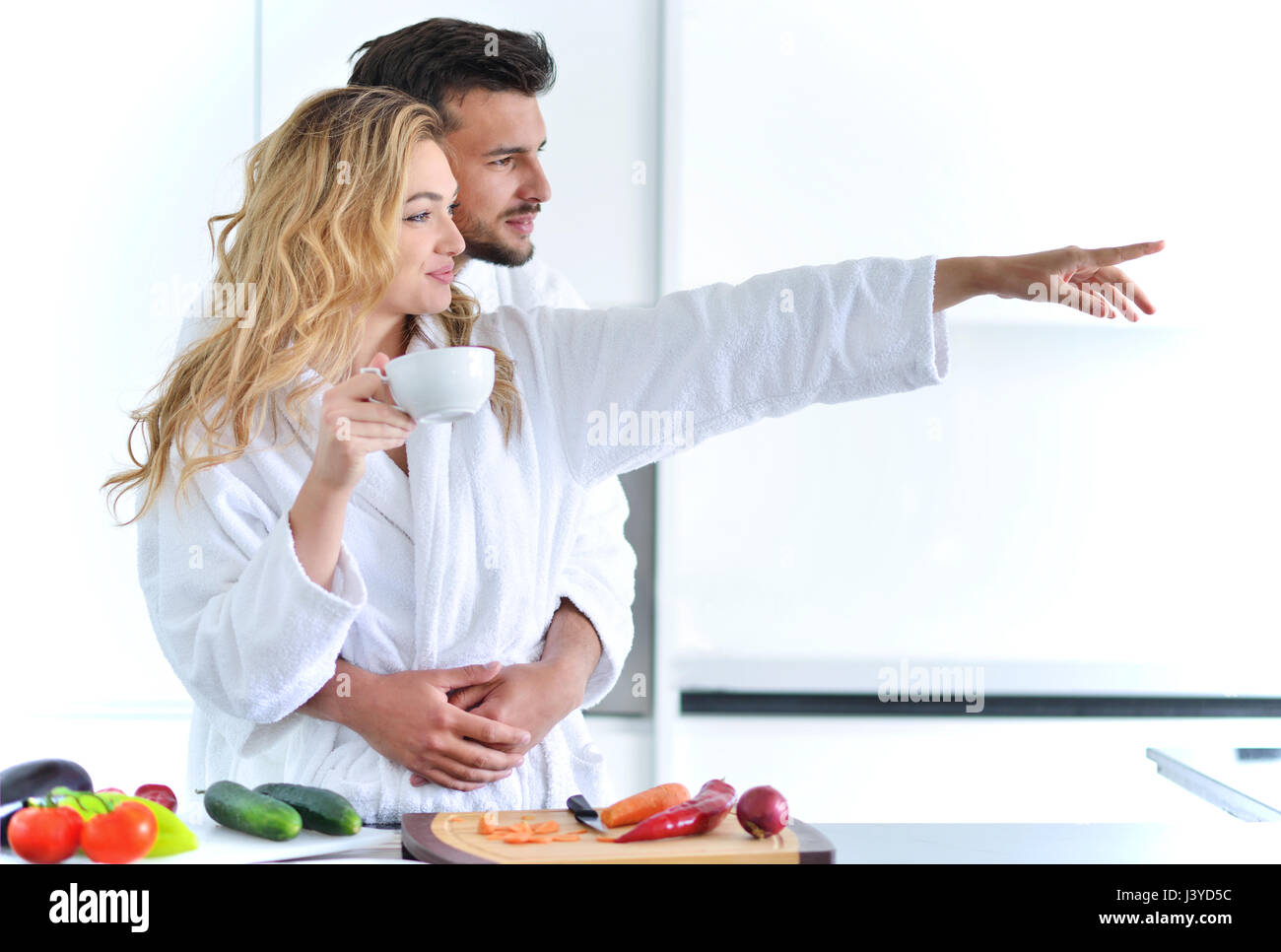 Happy couple cooking breakfast together in the kitchen Stock Photo - Alamy
