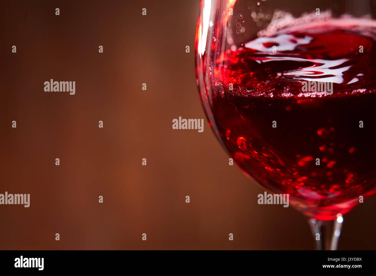 Close-up of the abstract splashing of the red wine in the fragile ...