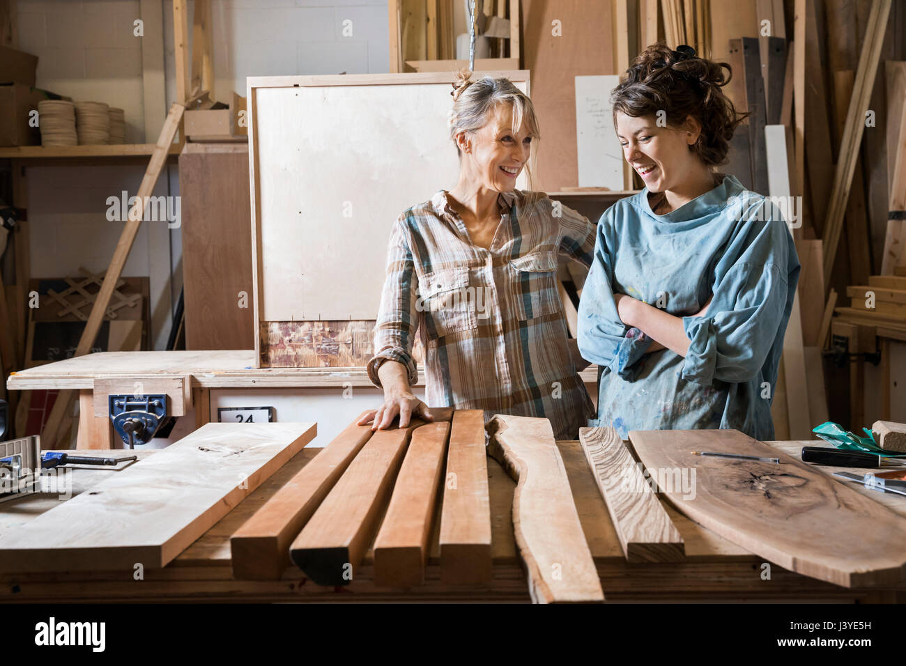 Two women choosing wood from a selection in a workshop Stock Photo - Alamy