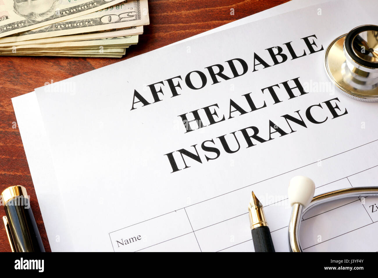 Affordable health insurance policy on a table Stock Photo - Alamy