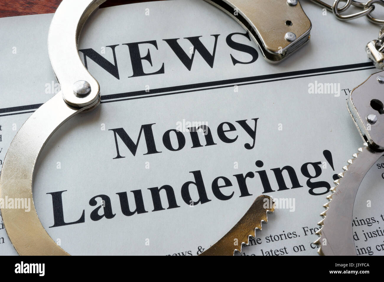 Newspaper with title Money laundering and handcuffs Stock Photo - Alamy