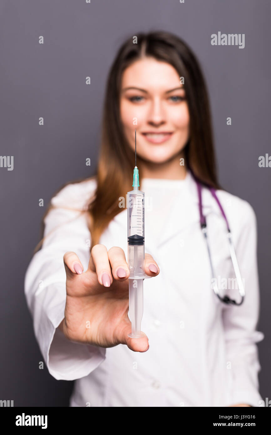 Woman young doctor with syringe on grey Stock Photo - Alamy