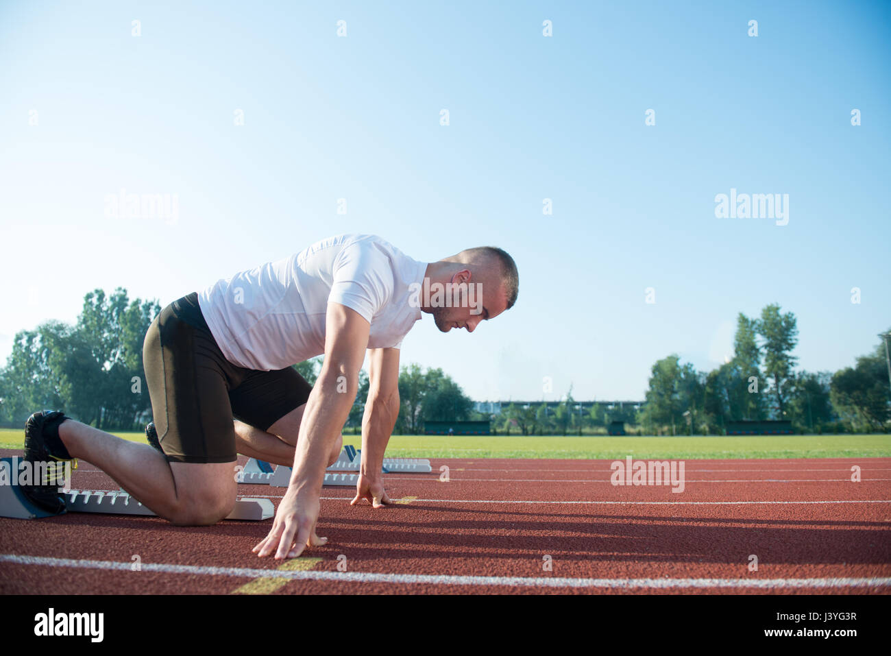 Runners preparing for race at starting blocks Stock Photo - Alamy