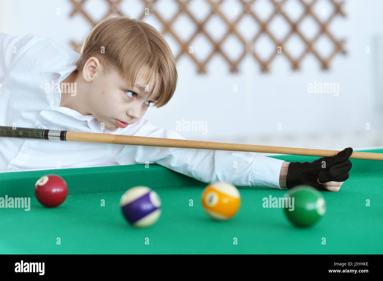 Boy playing billiards Stock Photo - Alamy