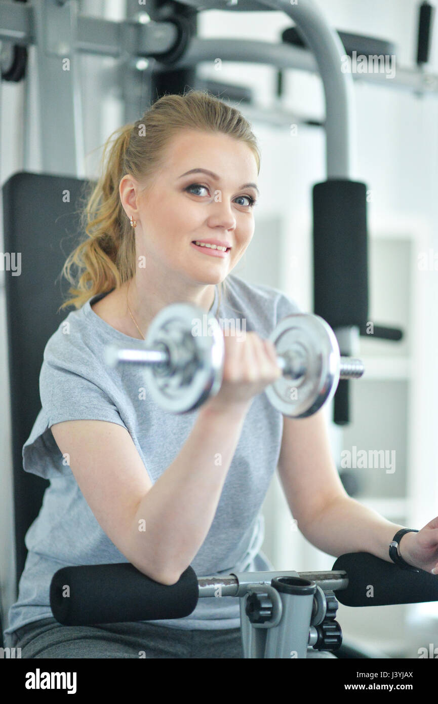 Young woman in a gym with a dumbbell Stock Photo - Alamy