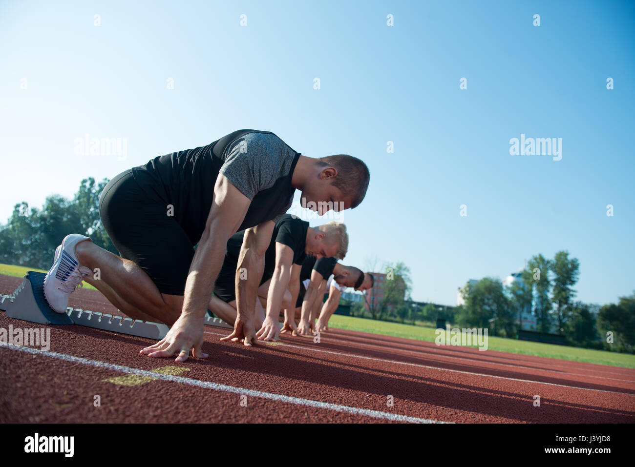 Runners preparing for race at starting blocks Stock Photo - Alamy